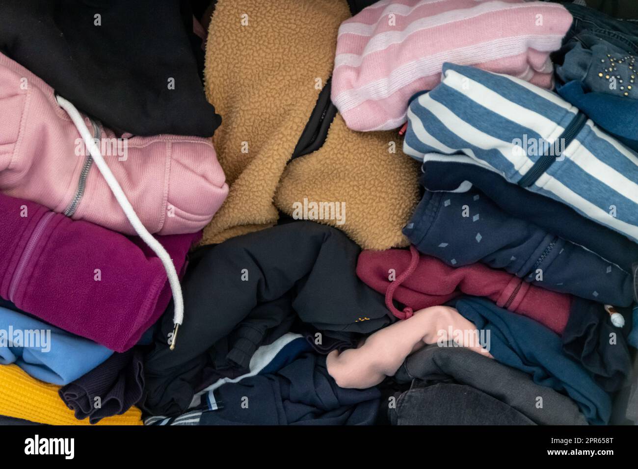 Chaotic wardrobe and sloppy closet shows many outfits of a woman with ...