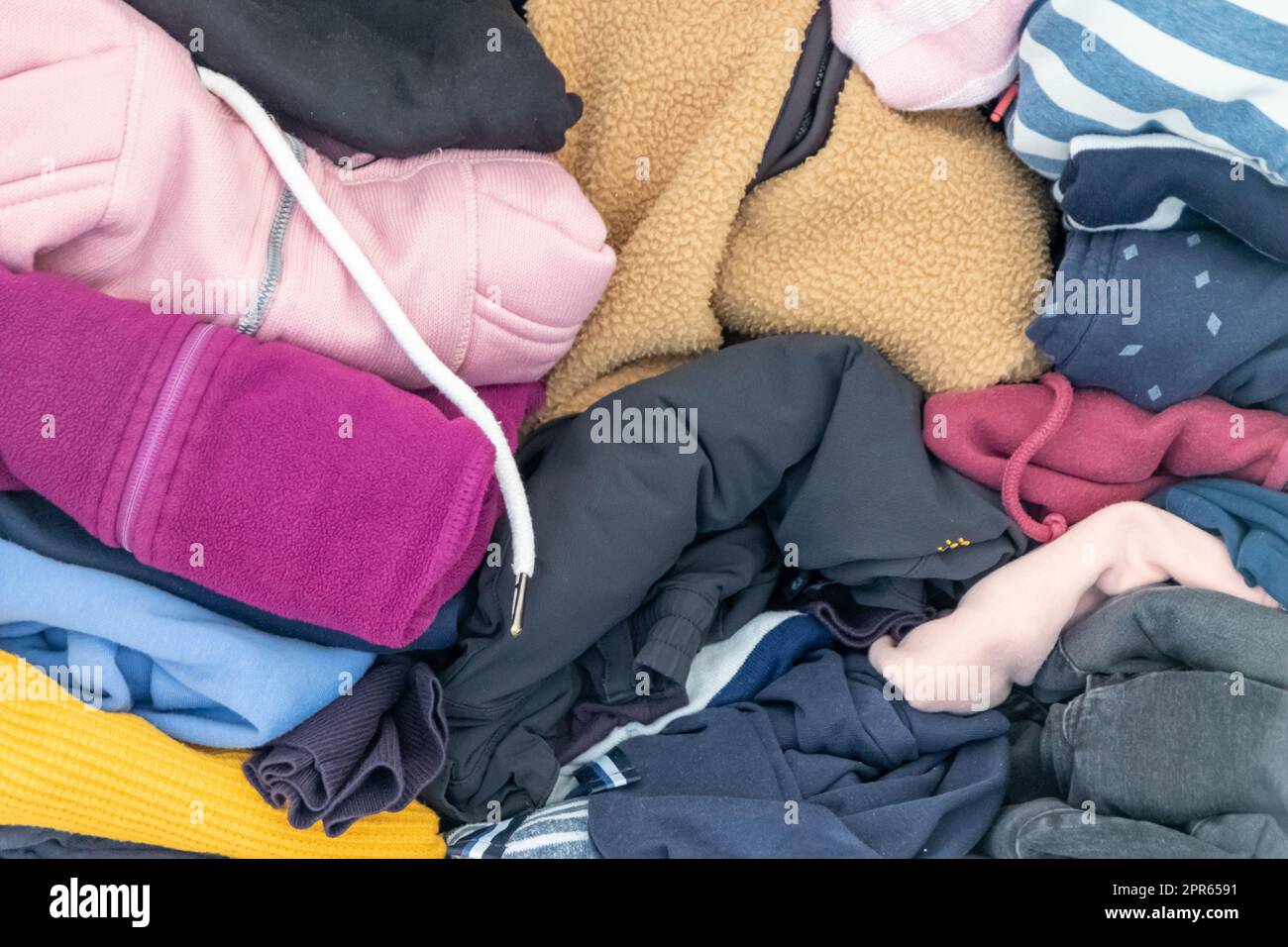 Chaotic wardrobe and sloppy closet shows many outfits of a woman with ...