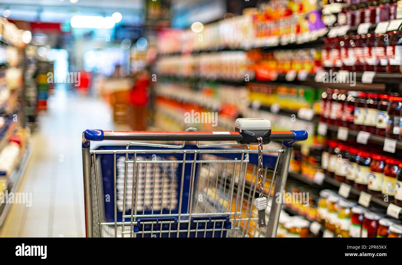 A shopping cart by a store shelf in a supermarket Stock Photo - Alamy