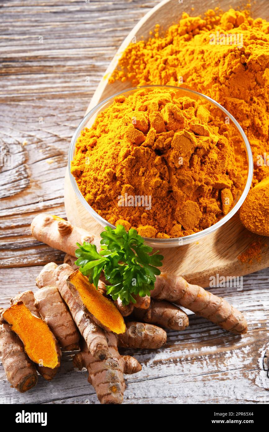 Composition with a bowl of ground turmeric and its fresh rhizome Stock ...
