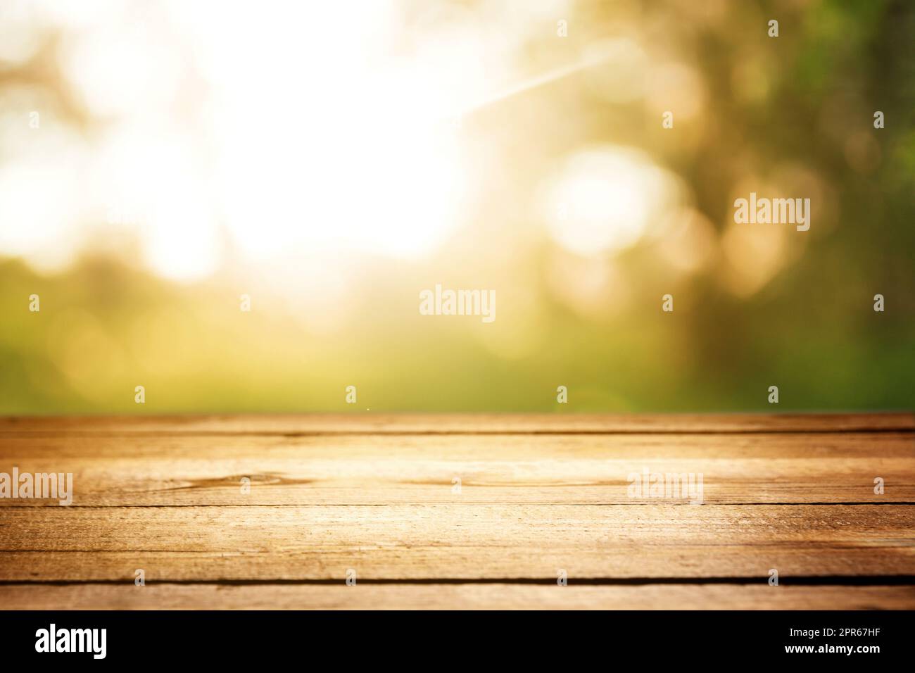 Empty blank wooden plank, deck or table with defocused green trees ...