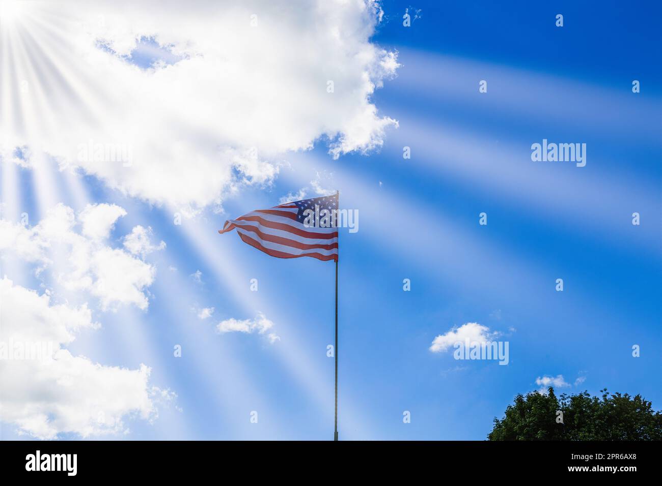 American flag waving in a cloudy sky and sunbeams. USA flag flies Stock ...