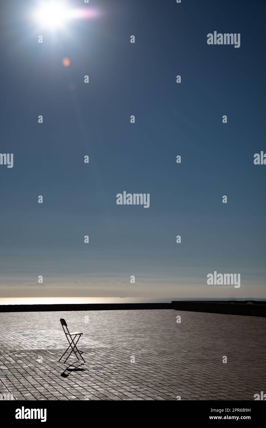 A wooden chair standing in the middle of an empty stage. Loneliness ...
