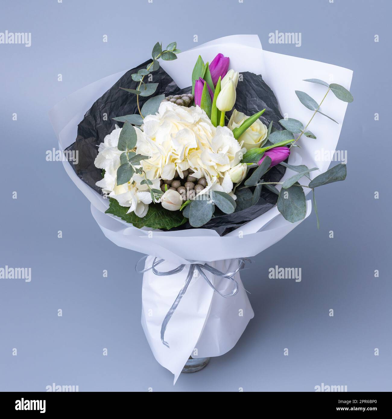 Delicate romantic bouquet of flowers wrapped in white paper Stock Photo ...