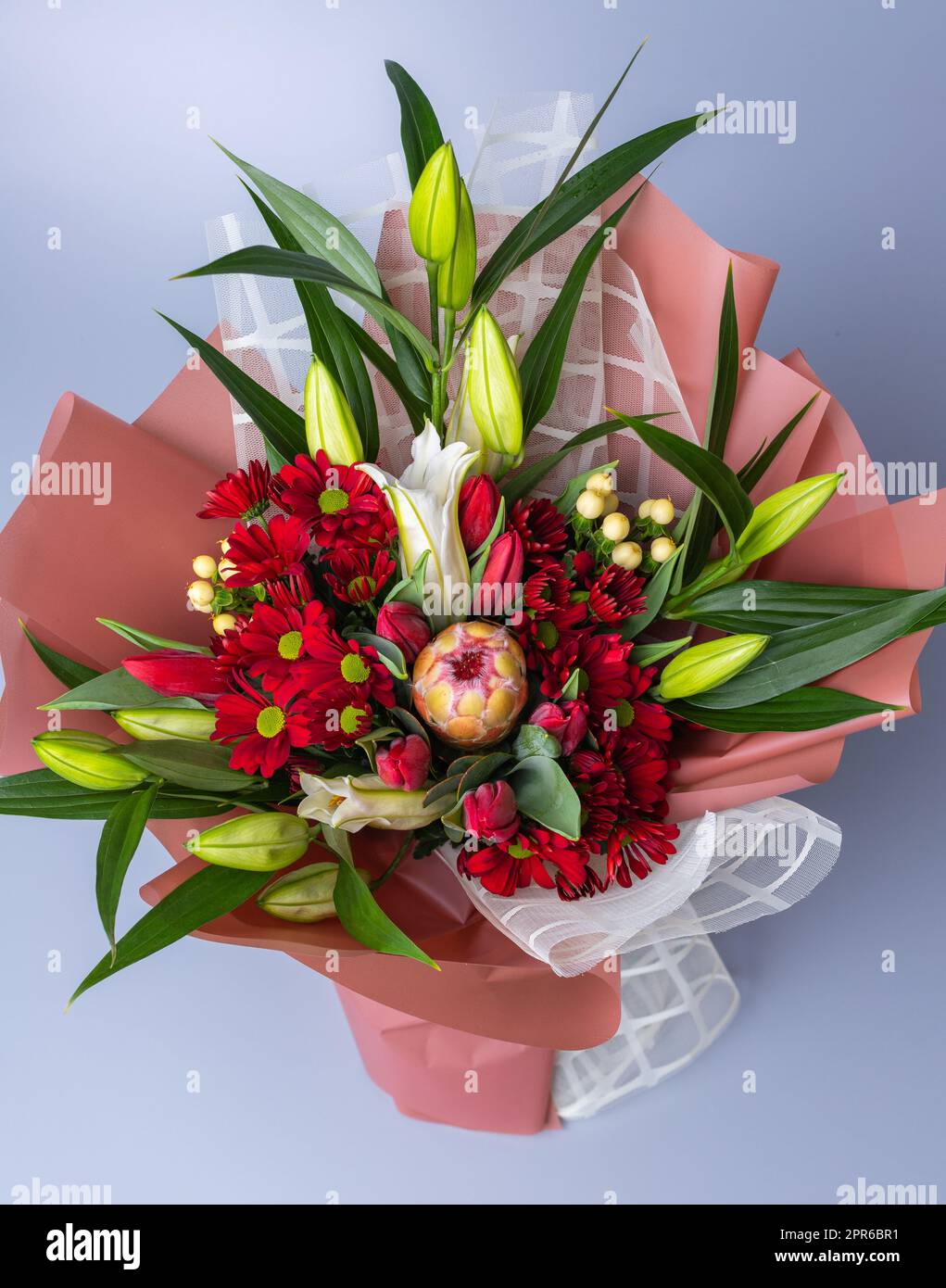 Top view of a bouquet of flowers packed in a white and pink wrapper ...