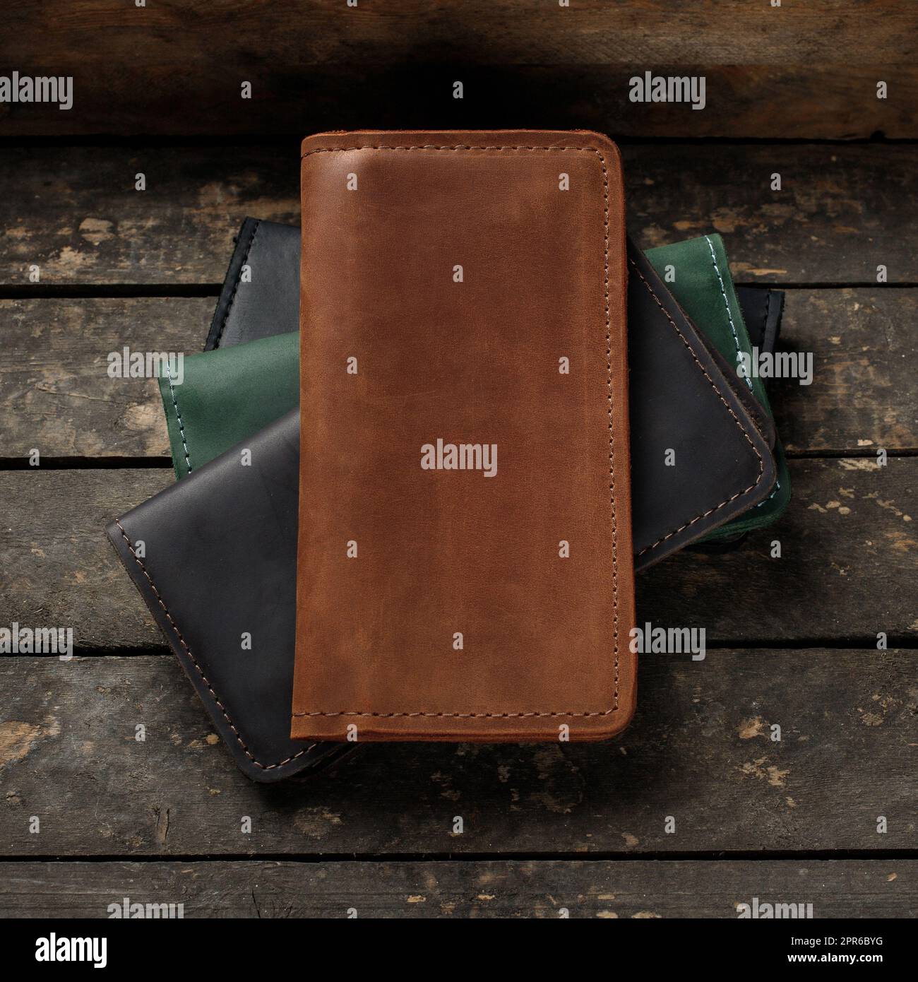 Set of stylish leather wallets on a vintage wooden background. Copy ...