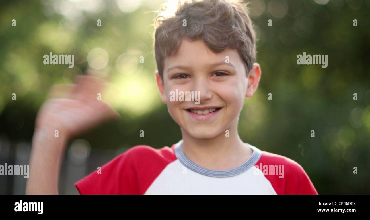 Happy cheerful child boy waving hello to camera with hand. Young boy ...