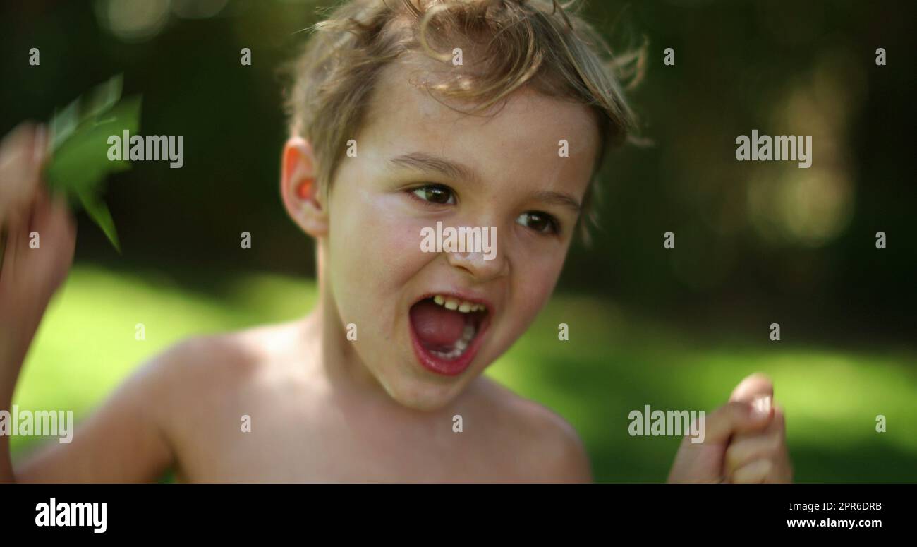 Happy excited infant toddler child jumping up and down outdoors. Kid ...