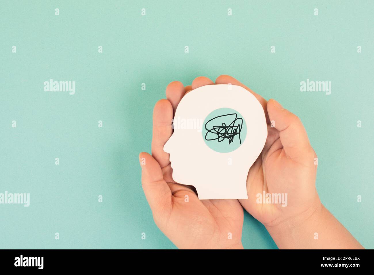 Hands holding a silhouette of a human head, attention deficit ...