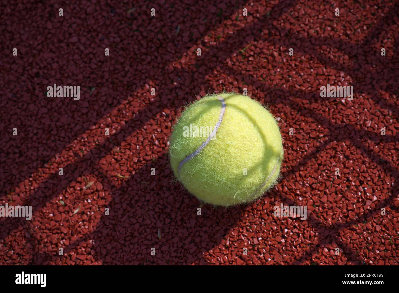 Shadows of net surrounding a tennis ball on court Stock Photo - Alamy