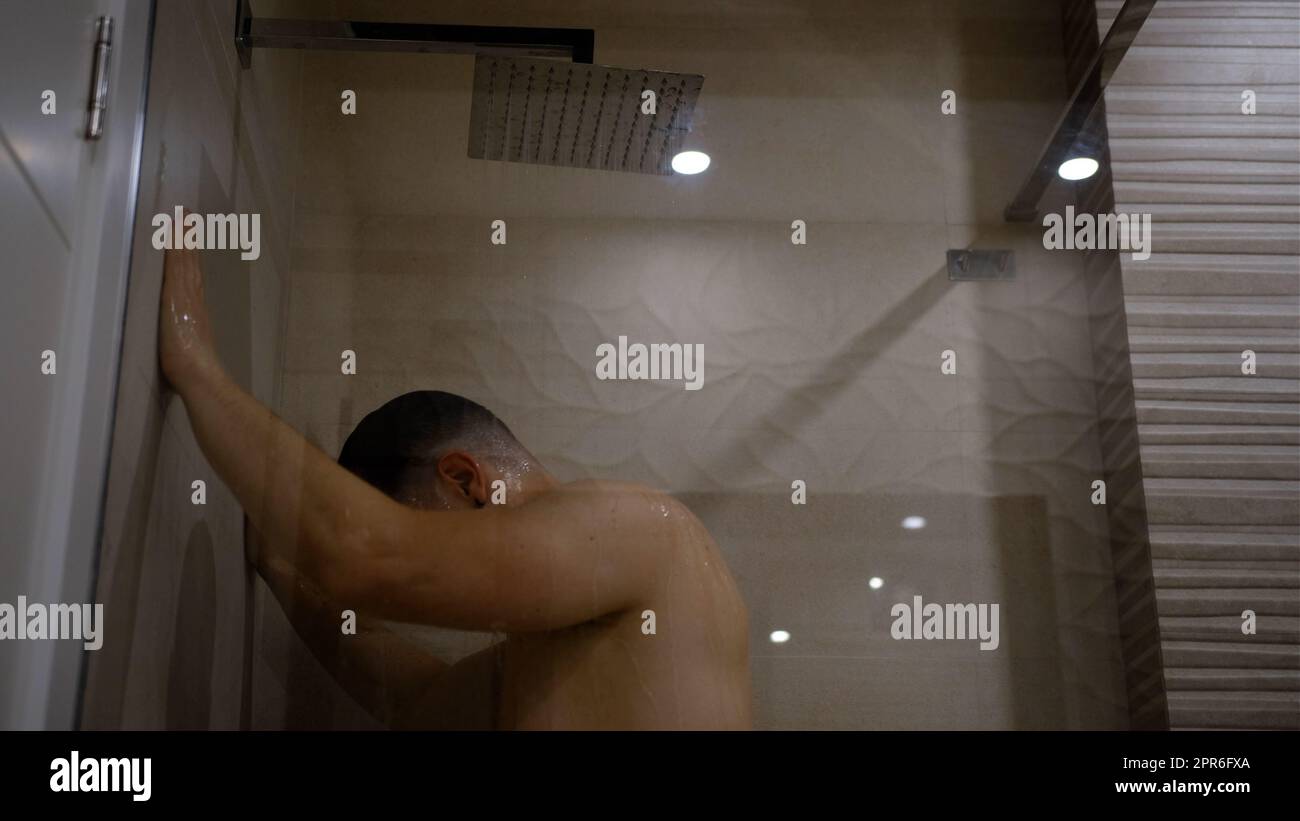 Guy washing hair under shower hi-res stock photography and images - Alamy
