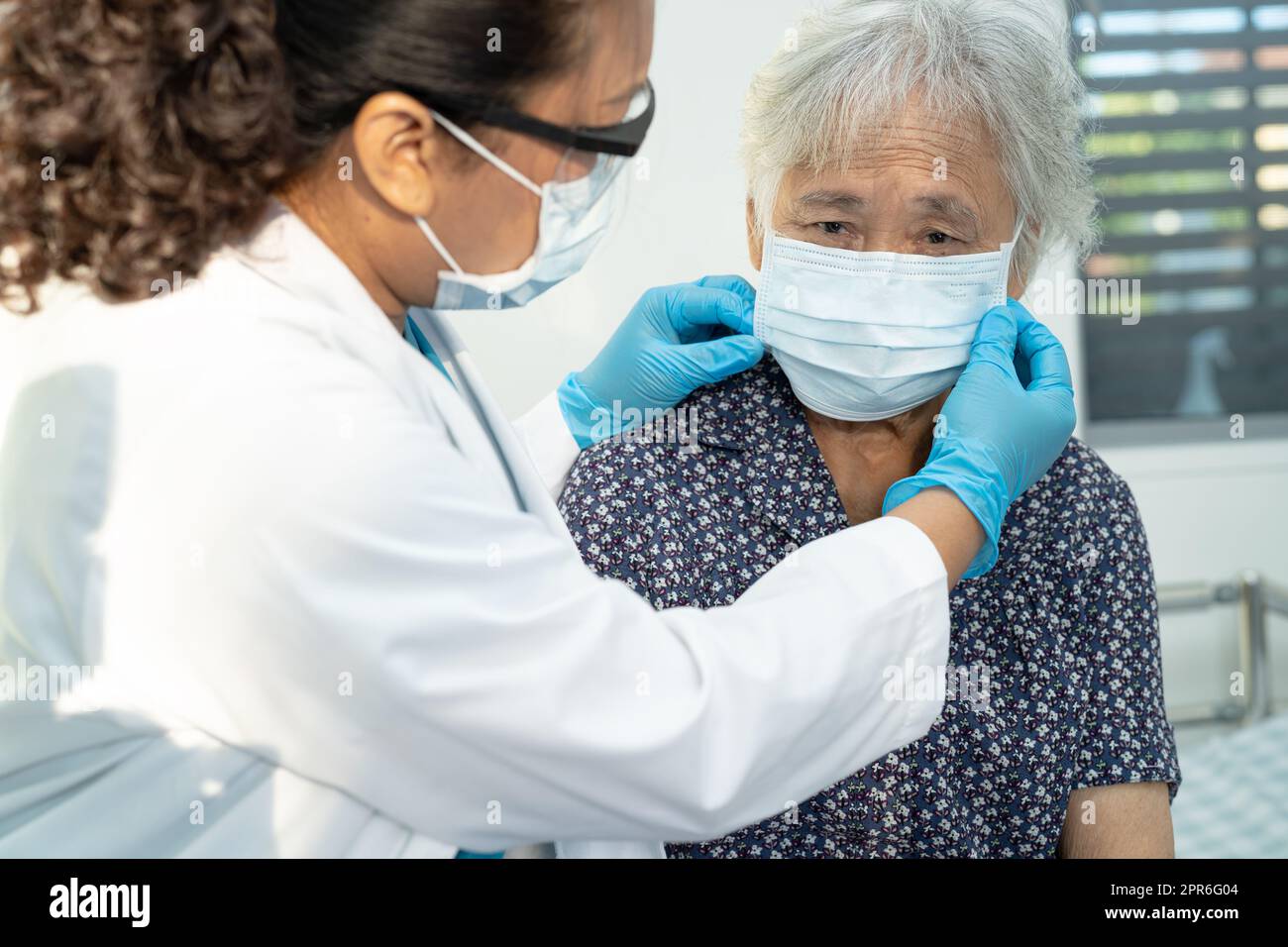 Asian doctor wearing face shield and PPE suit new normal to check ...