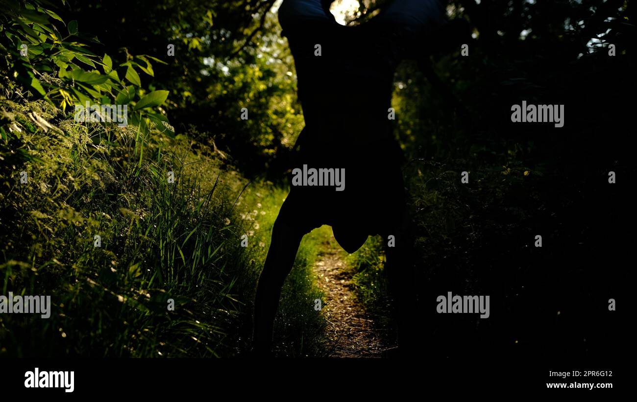 man walks on hands in the forest at sunset, sunrise Stock Photo - Alamy