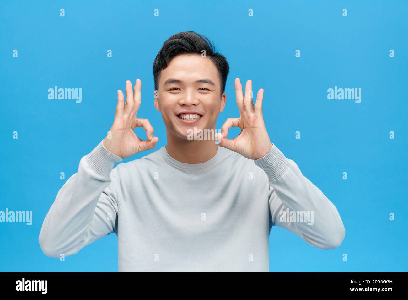 Portrait of happy excited asian guy doing approval ok gesture with ...