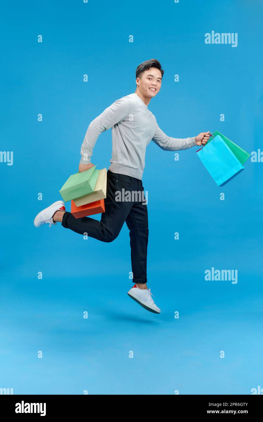Full length profile photo of handsome man carry bags jump high isolated ...