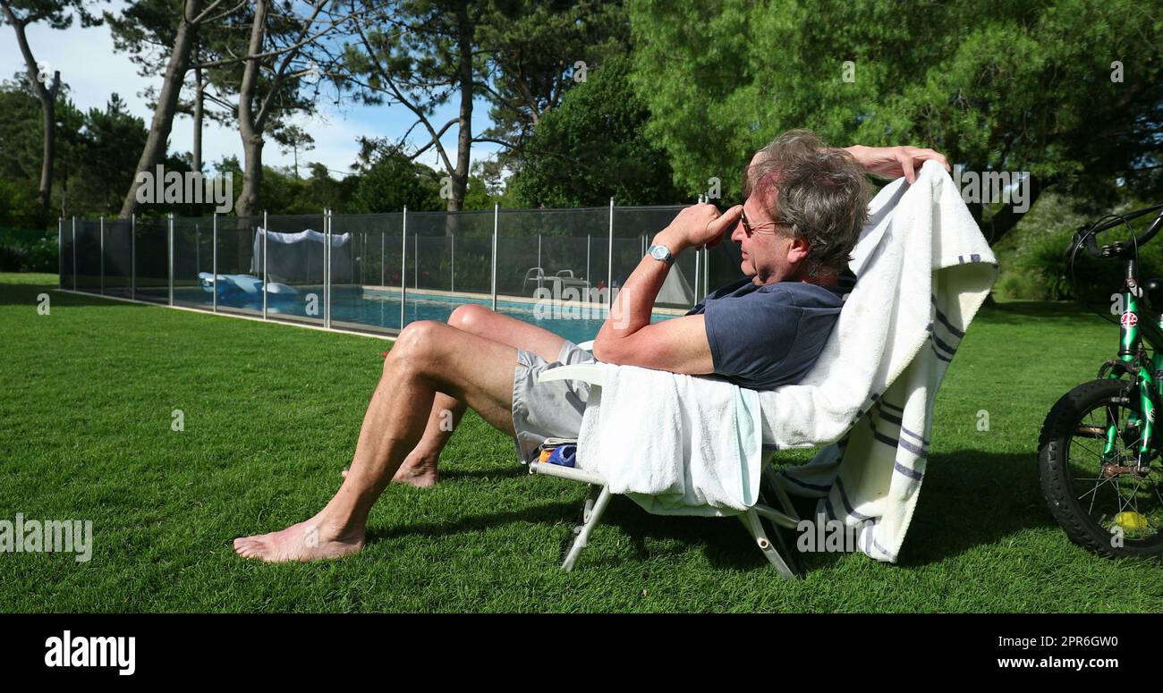 Older man resting sitted outside in home garden. Senior person in ...