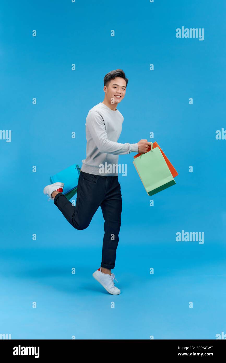 Full size photo of crazy handsome guy hurry rush hold packages jump ...