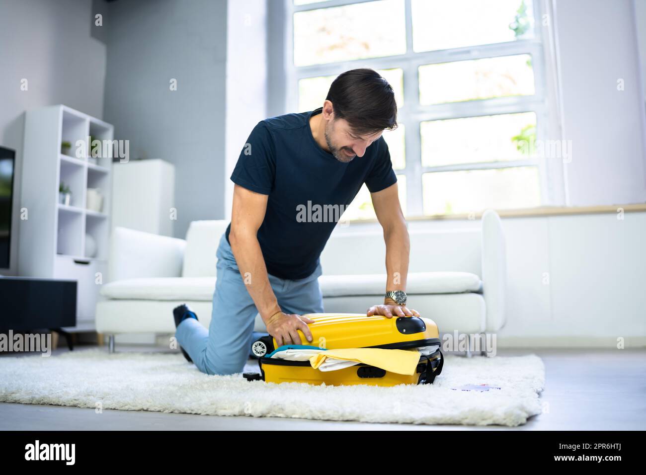 Man Packing Stuffed Suitcase Bag Stock Photo - Alamy