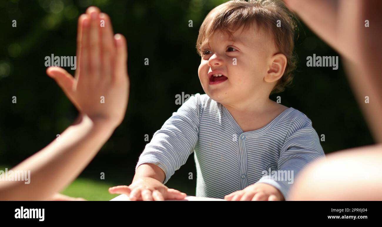 Infant toddler observing kids doing high-five. Children doing high five ...
