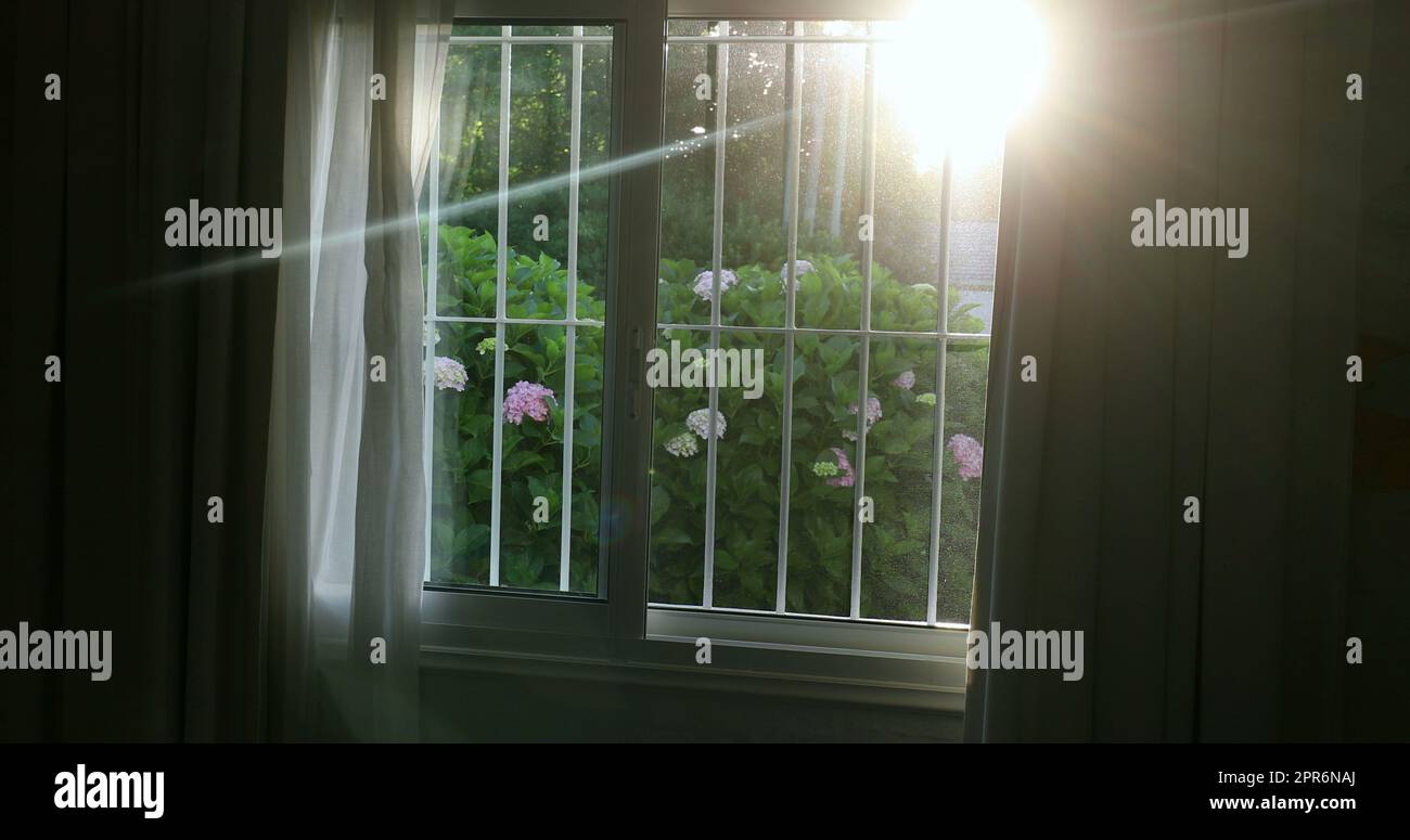 Lens-flare sunflare shining through home window during sunset golden ...