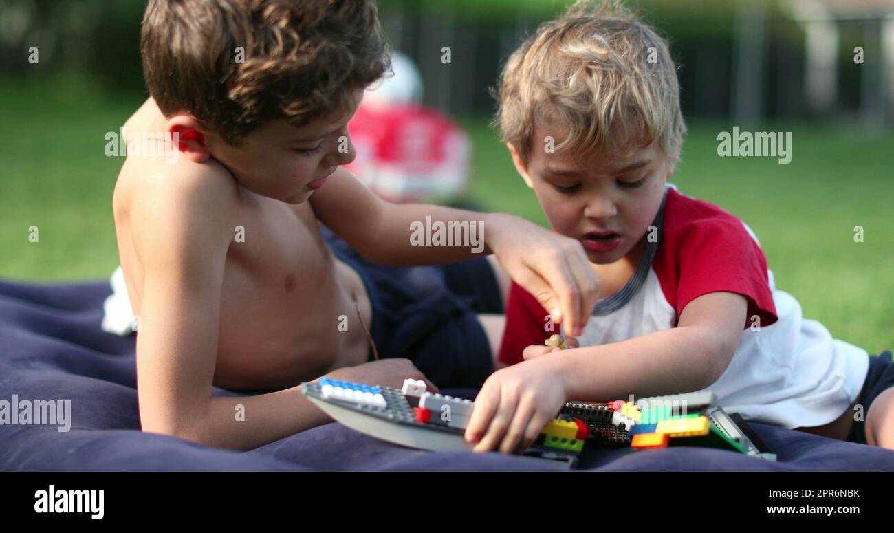 Kids playing with toys outside in home backyard. Authentic real life ...