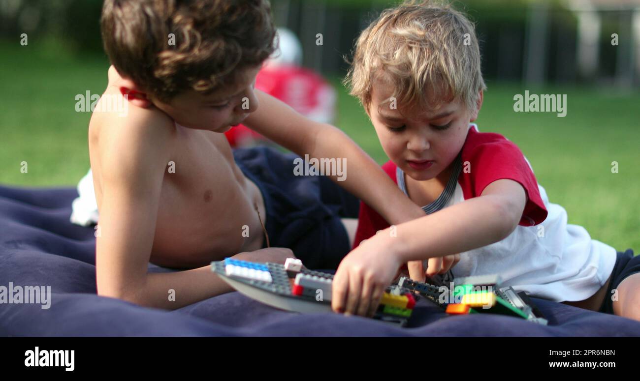Kids playing with toys outside in home backyard. Authentic real life ...