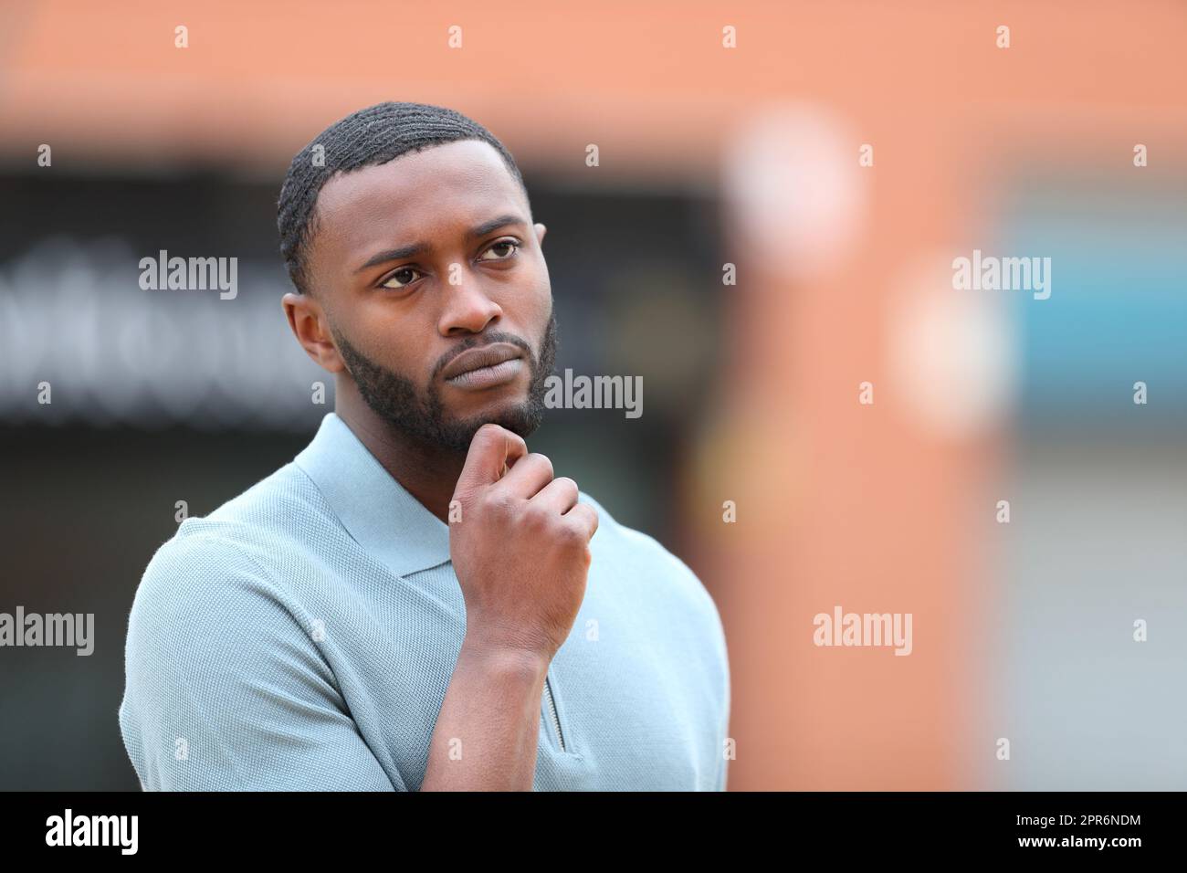 Black man thinking looking at side in the street Stock Photo - Alamy