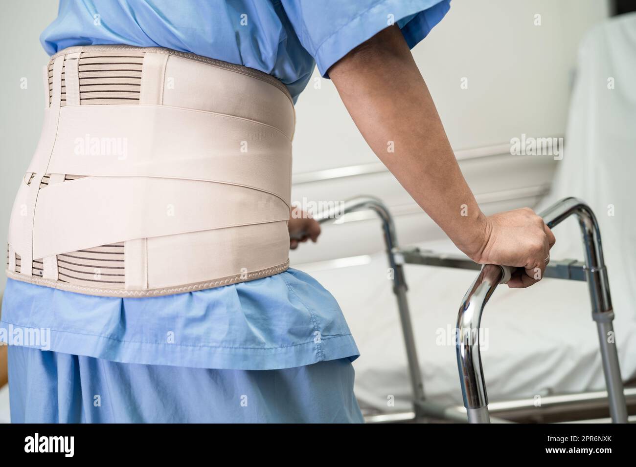 Asian lady patient wearing back pain support belt for orthopedic lumbar ...