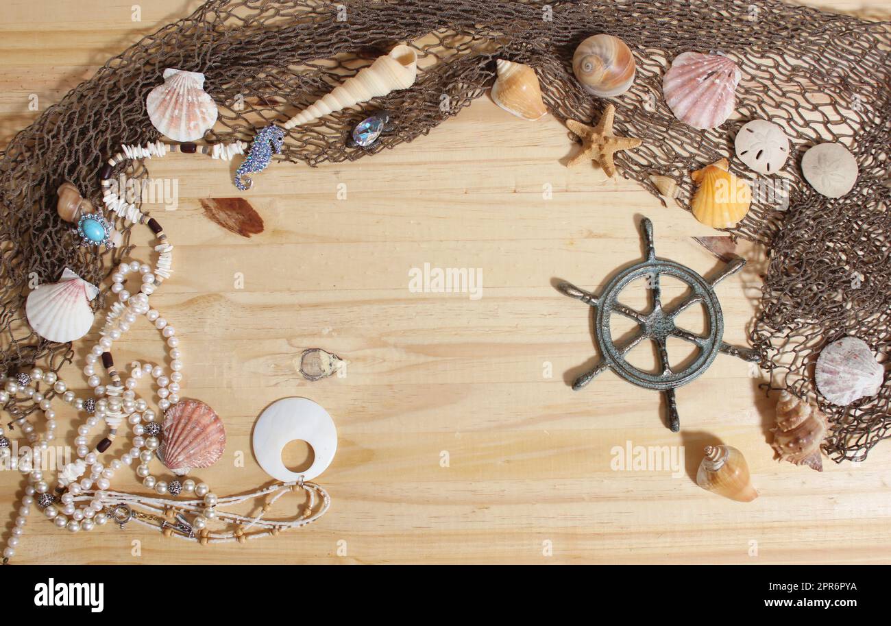 Captains Wheel With Fishing Net and Sea Shells on Wooden Background ...