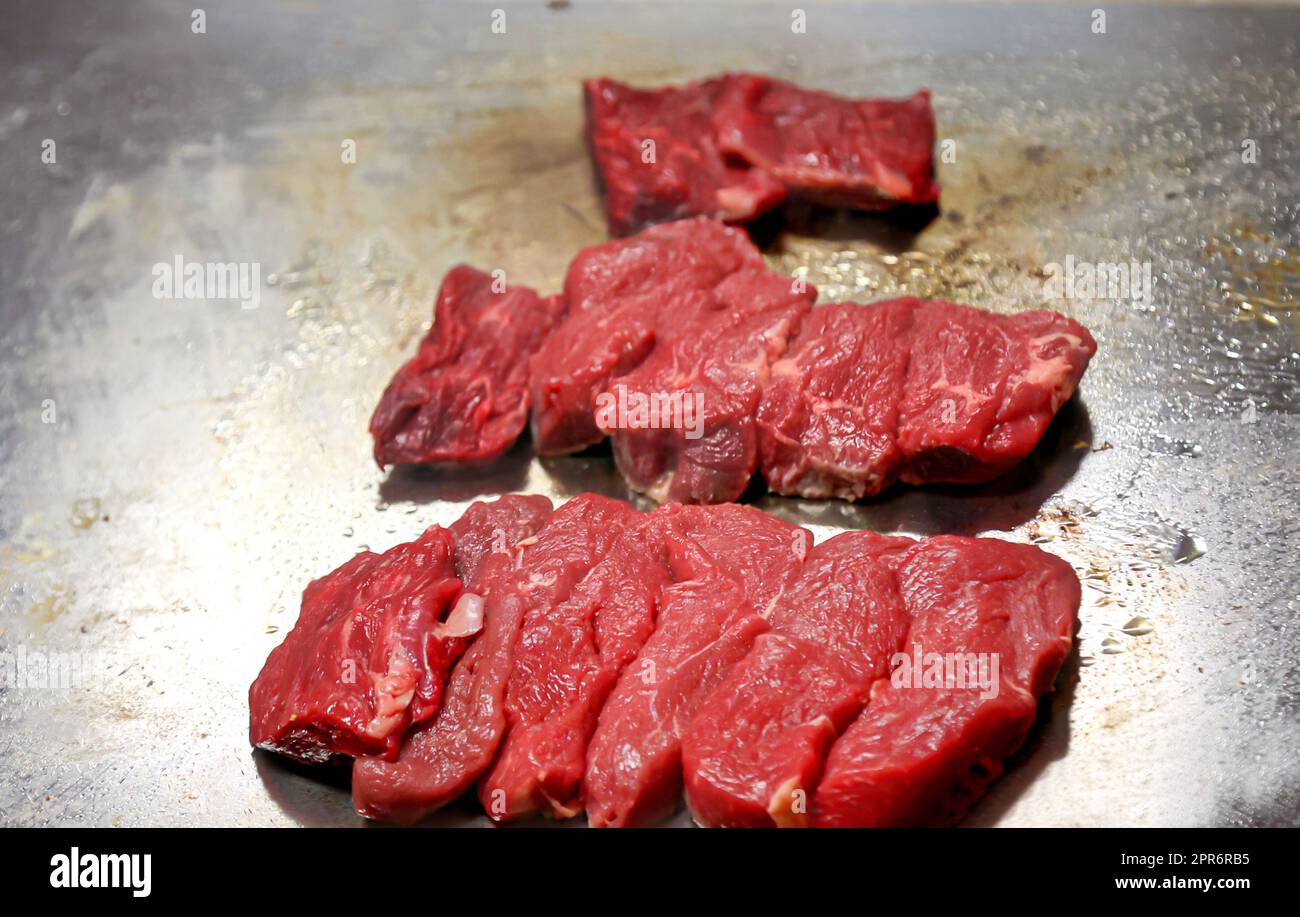 Preparation of fine beef, meat on a hot cooking plate Stock Photo - Alamy