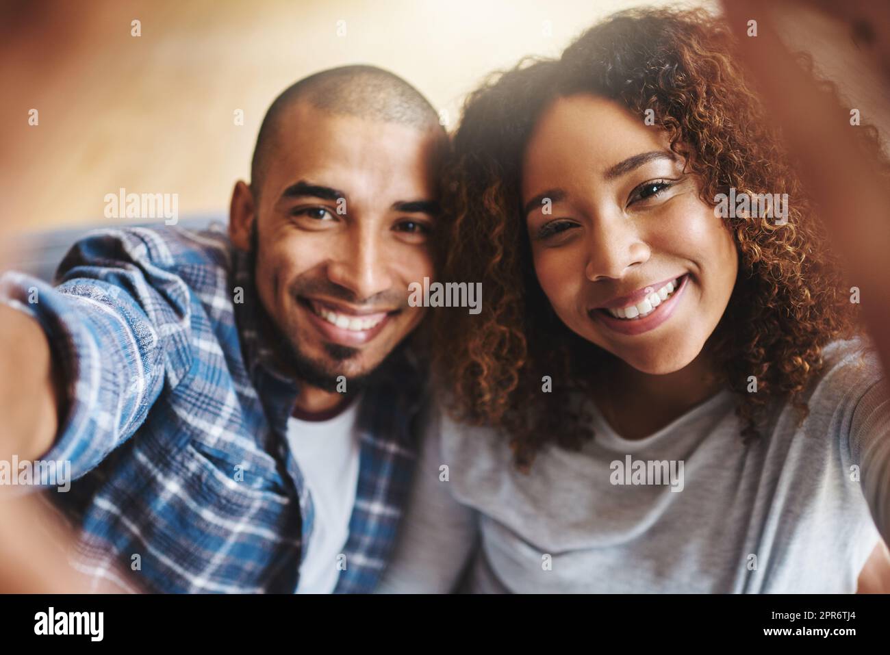 Capturing memories. Cropped portrait of an affectionate young couple sitting on their sofa ...