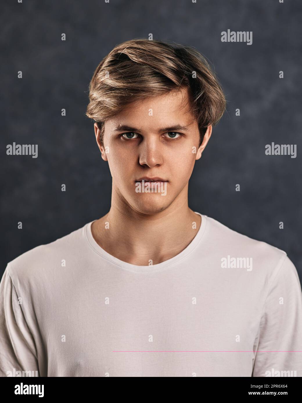 young man frowning on gray background. Human emotions Stock Photo - Alamy