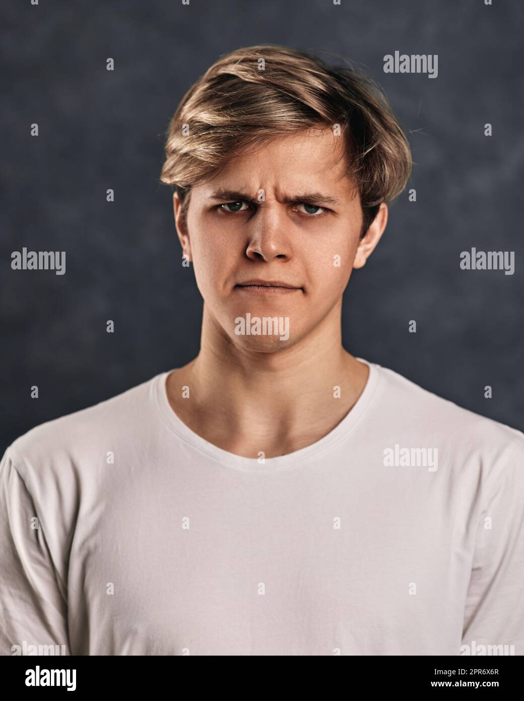 young man frowning on gray background. Human emotions Stock Photo - Alamy