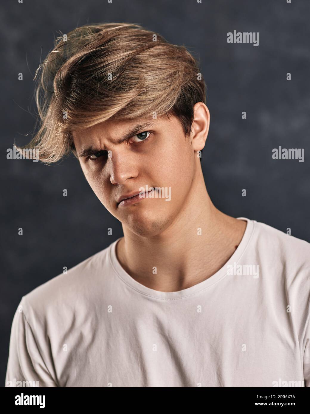 young man frowning on gray background. Human emotions Stock Photo - Alamy