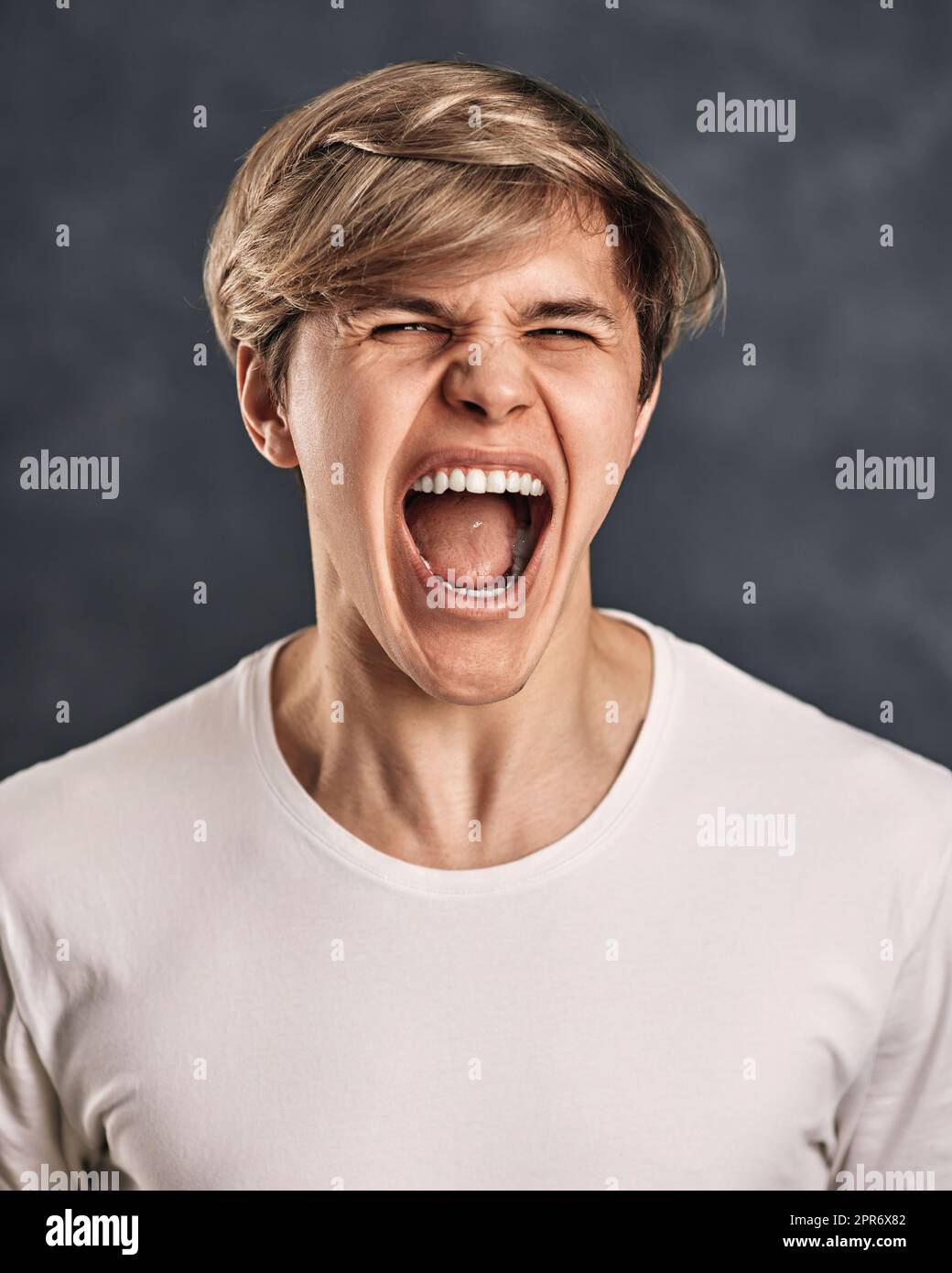 Furious, enraged young man over gray background Stock Photo - Alamy