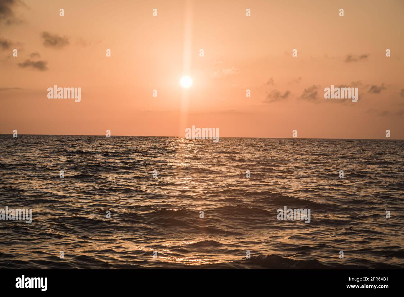 Colorful ocean beach sunrise with deep blue sky and sun rays Stock Photo - Alamy