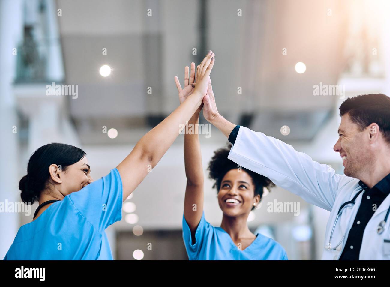 We did it together. Shot of a diverse team of doctors giving each other ...