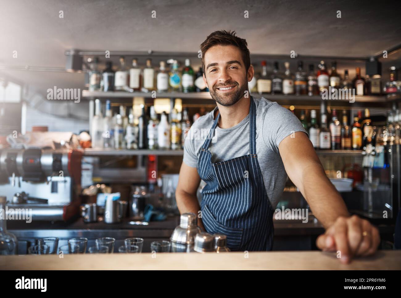 Portrait of a confident young man working behind a bar counter Stock ...