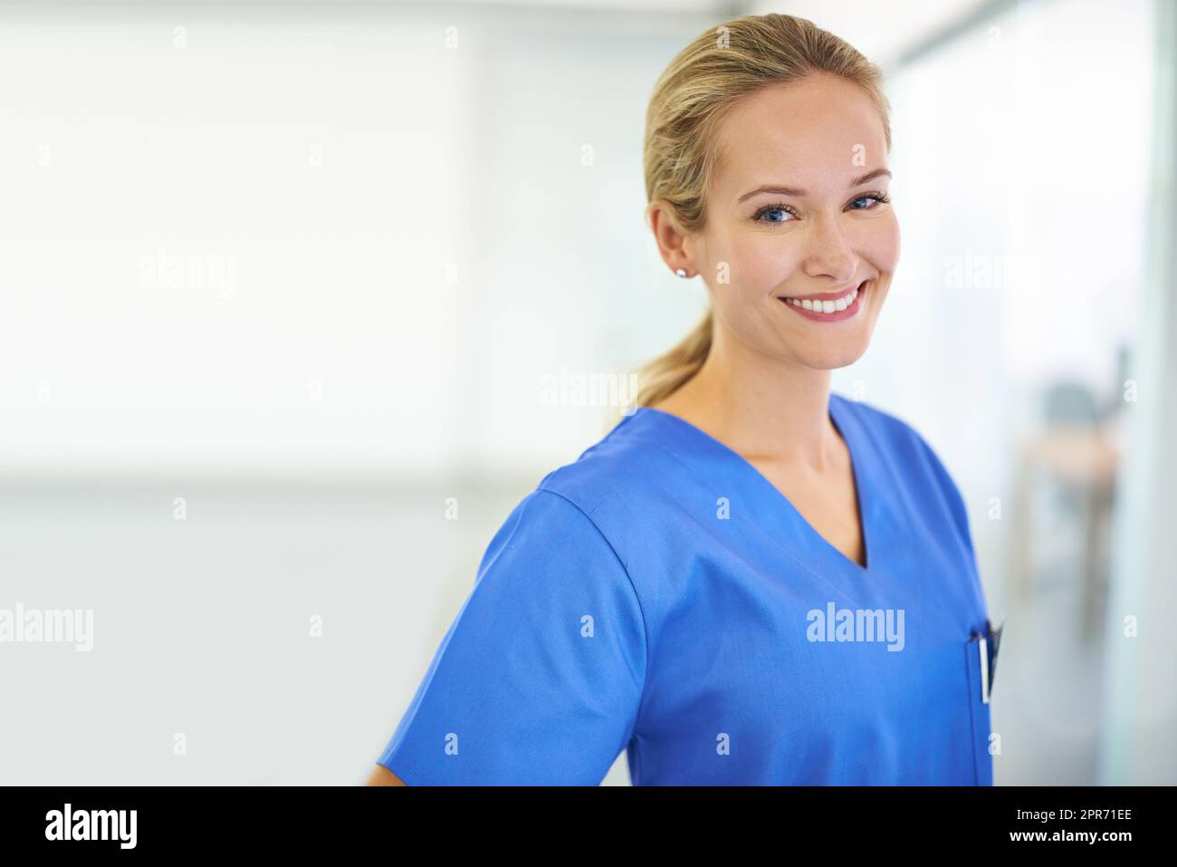 Portrait of a confident young doctor wearing blue scrubs Stock Photo ...