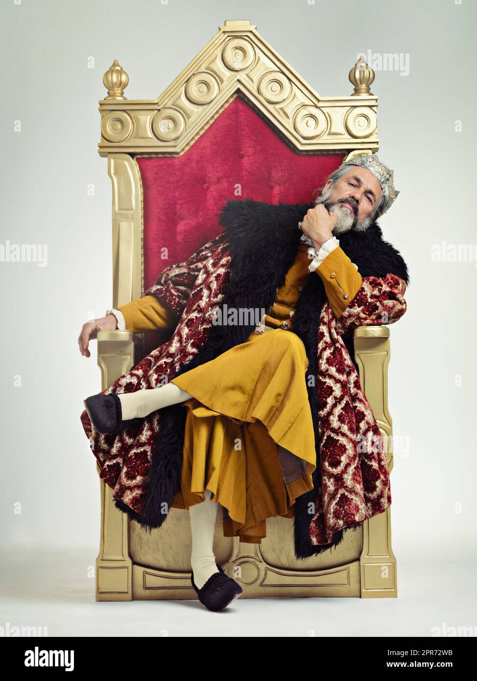 Studio shot of a richly garbed king sitting on a throne Stock Photo - Alamy