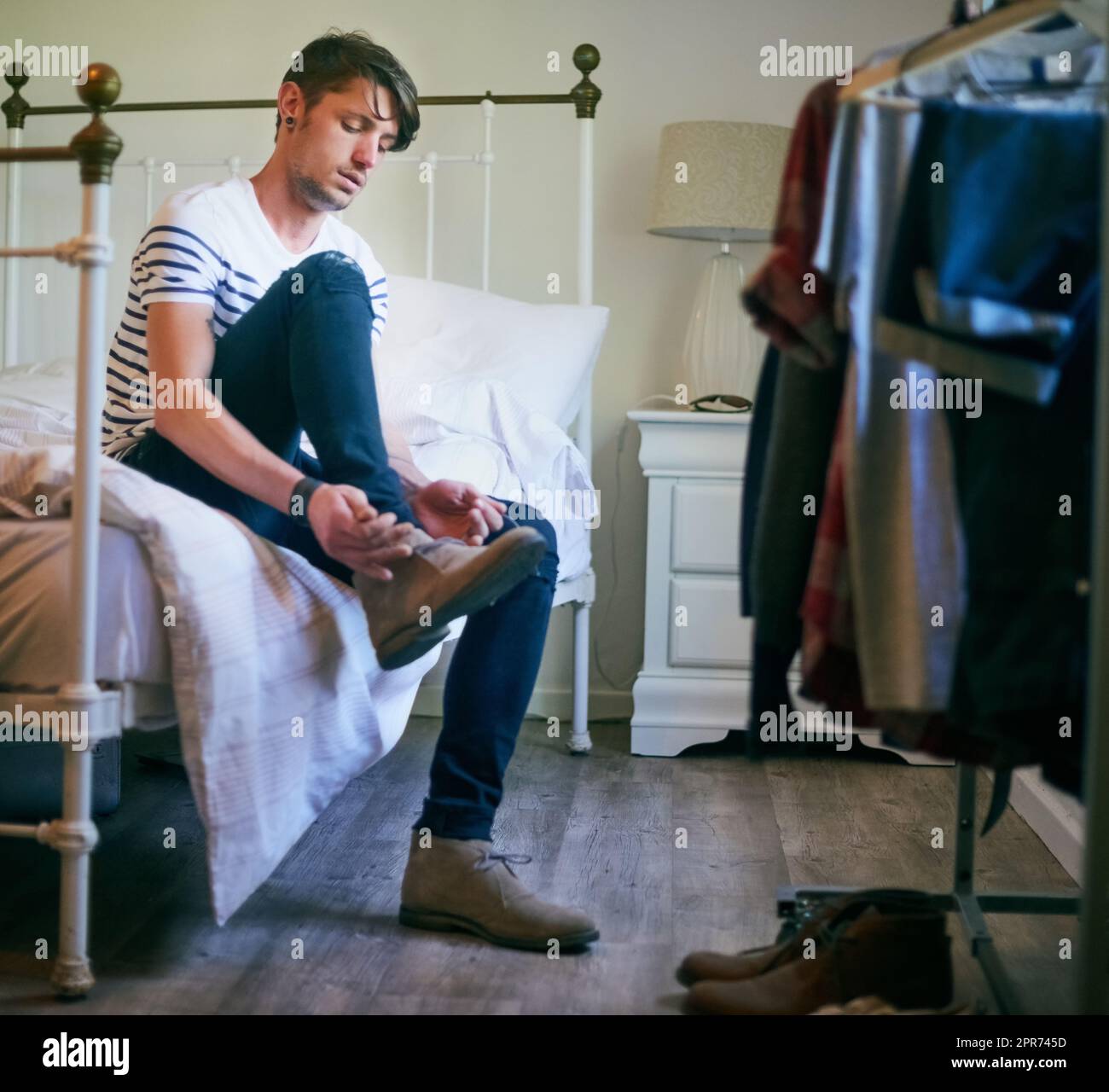 Getting ready for his day. Shot of a handsome young man sitting on his ...