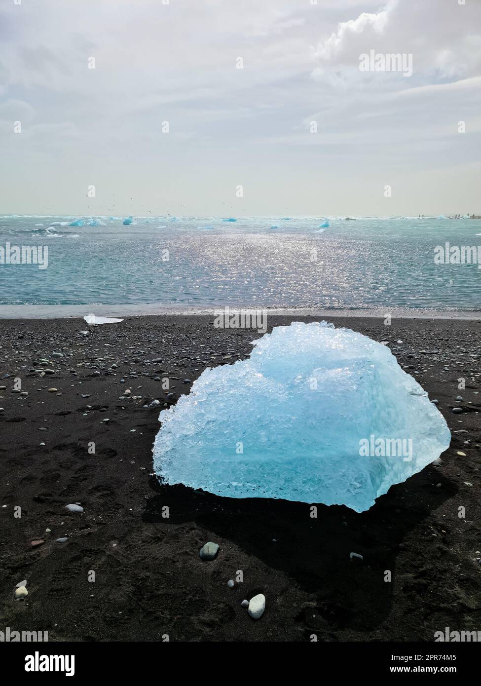 Diamond Beach in Iceland with blue icebergs melting on black sand and ...