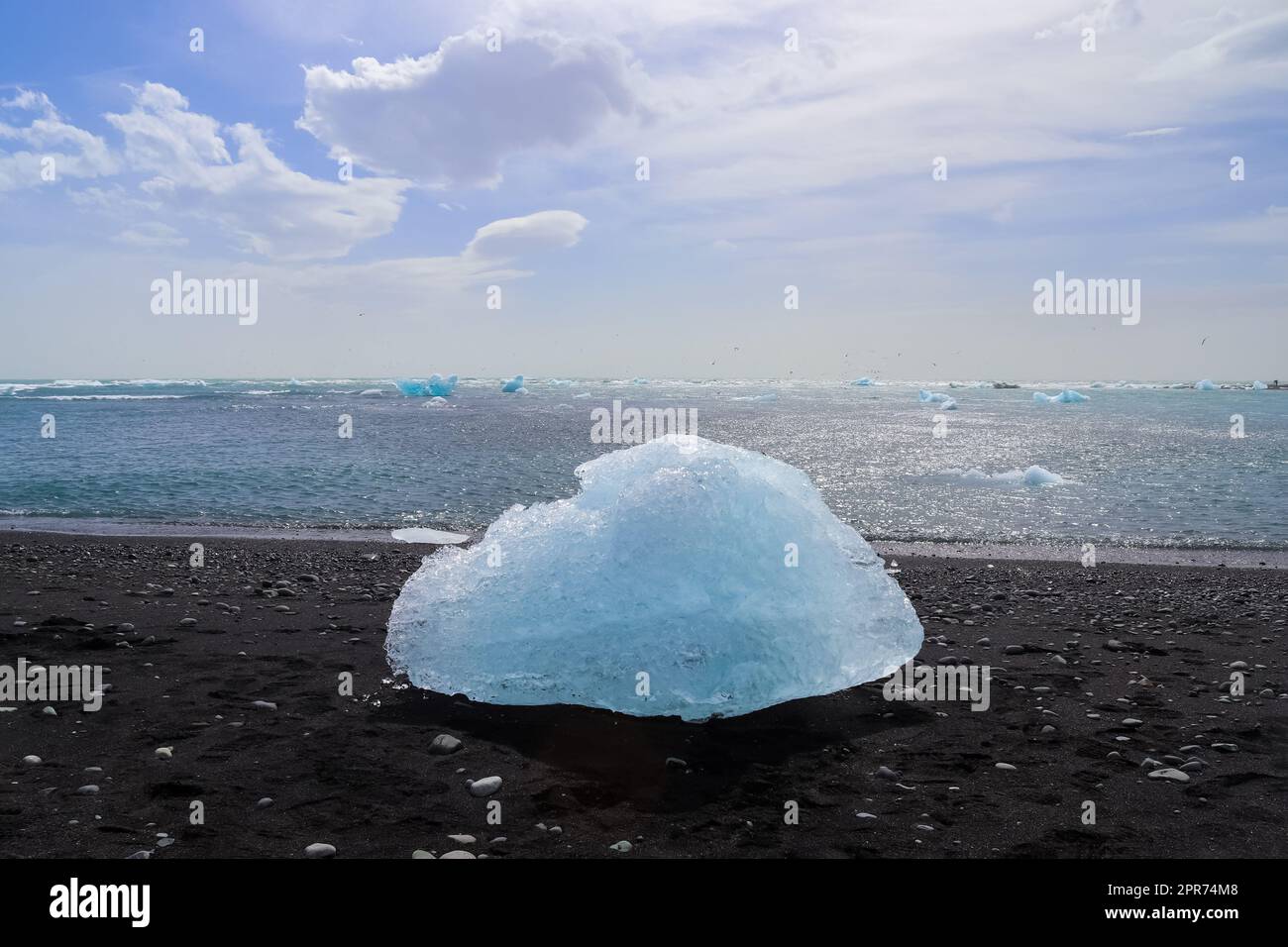 Diamond Beach in Iceland with blue icebergs melting on black sand and ...