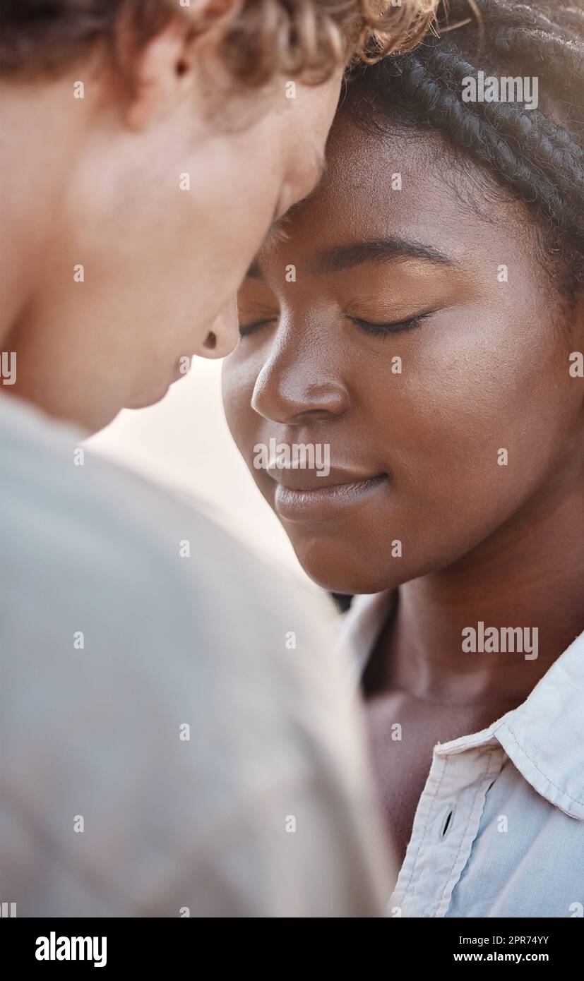 A Young Mixed Race Couple Enjoying A Day At The Beach Looking Happy And