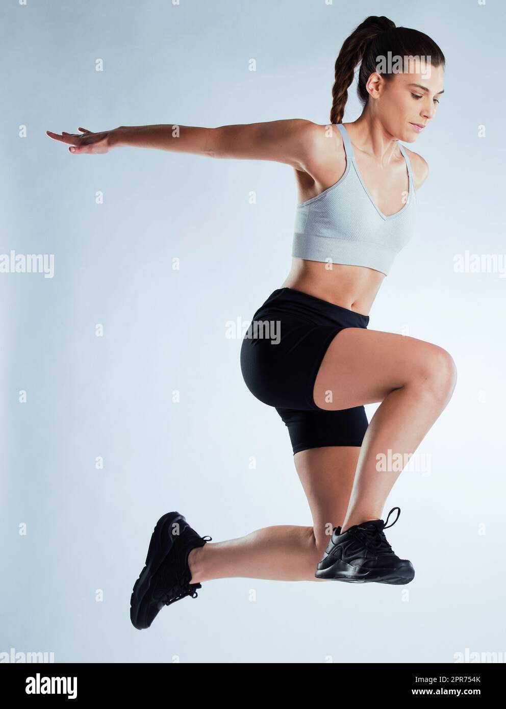 Put your back in to it. Full length shot of an attractive young female athlete posing in studio ...