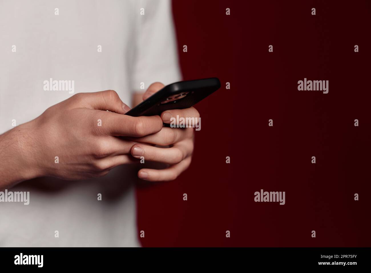 male hands texting on phone screen on red background Stock Photo - Alamy