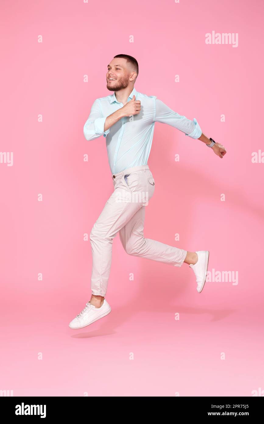 man in summer clothes jumping on pink background Stock Photo - Alamy