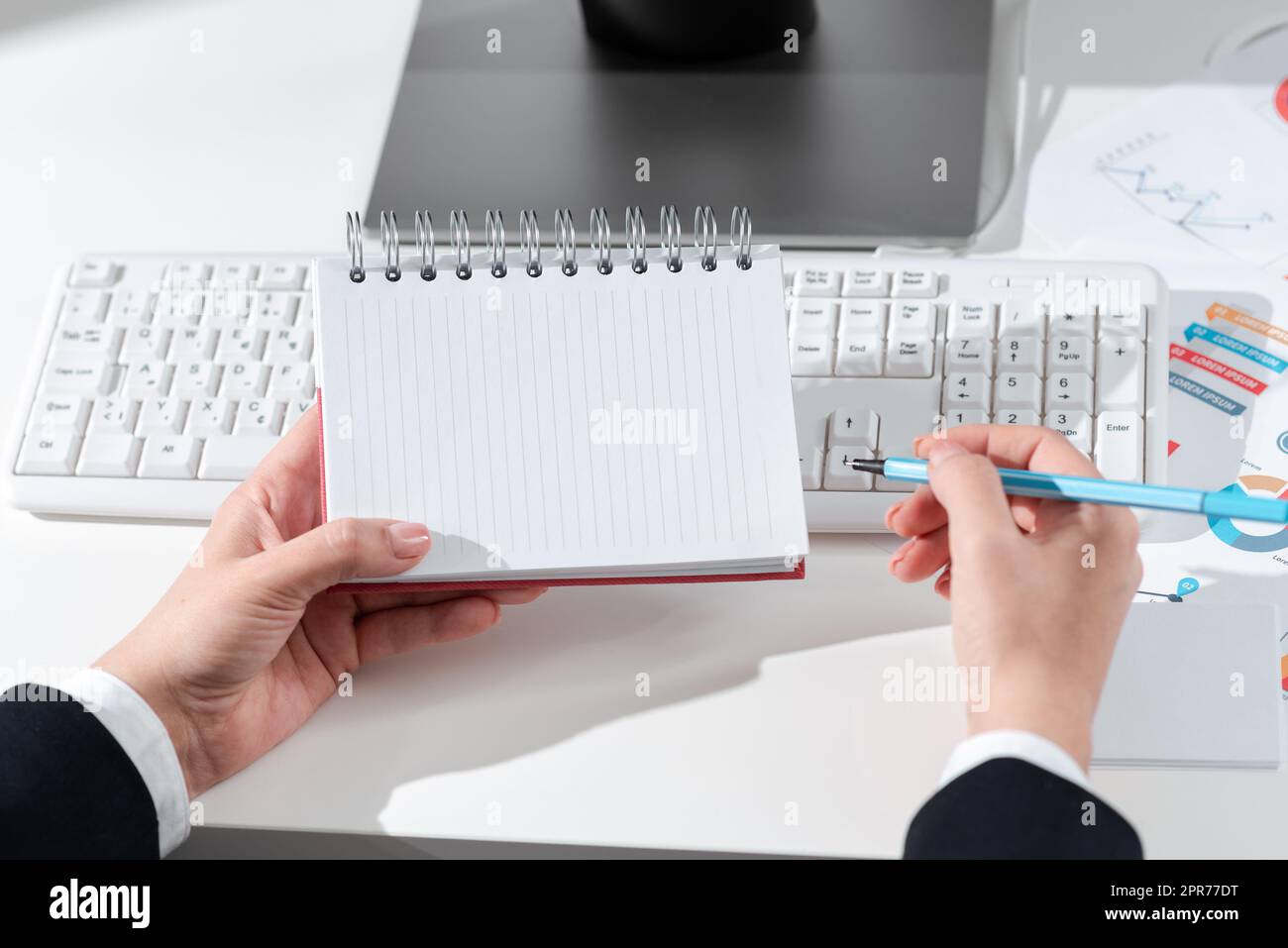 Businesswoman Holding Pen And Notebook With New Ideas Over Desk With ...