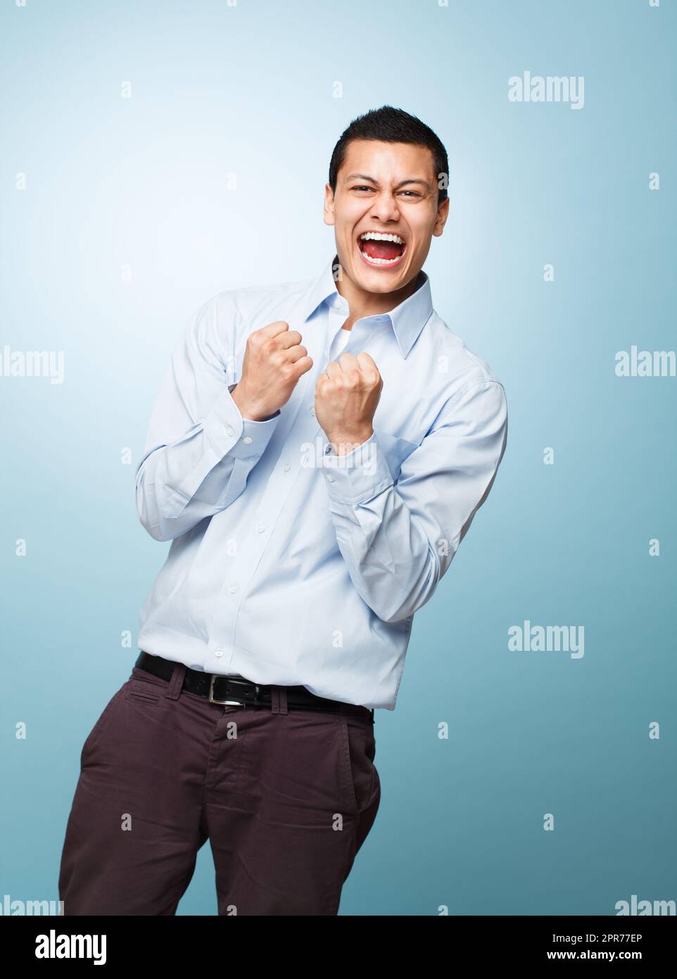 Success is very becoming for a young man. Shot of a young man shouting ...