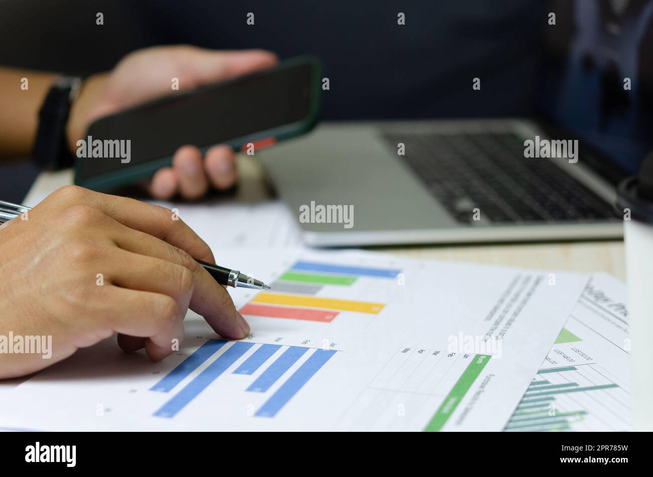 businessman holding pen to work computer graphs and charts data ...